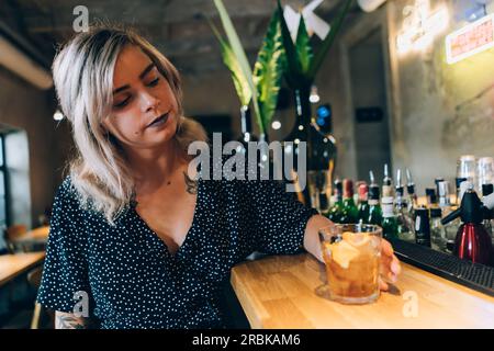 Blonde Girl In A Cocktail Bar Stock Photo - Alamy