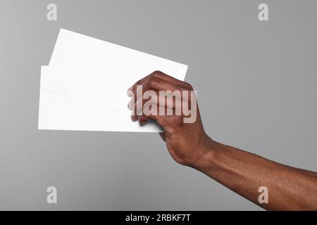 African American man holding flyers on white background, closeup ...
