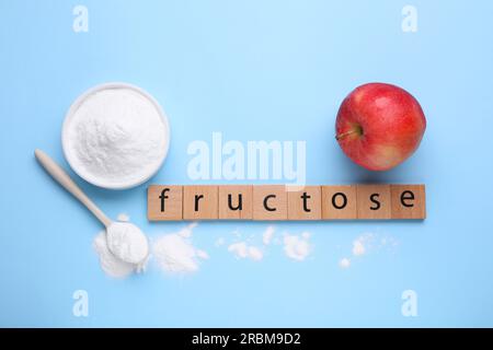 Word Fructose made of wooden cubes and powder on light green background ...