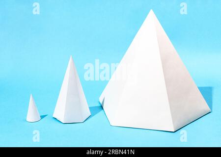 handmade different paper cone and pyramids close up on turquoise blue ...
