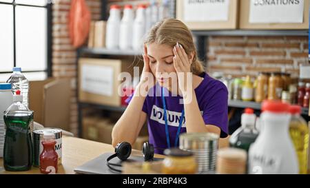 Young blonde woman volunteer sitting on table doing come gesture at ...