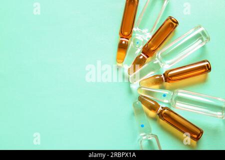 Glass medical ampules on turquoise background Stock Photo - Alamy
