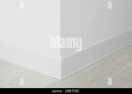 White plinth with connector on laminated floor near wall indoors ...