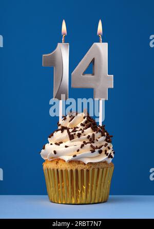Birthday number 14 - Candle lit on blue background Stock Photo - Alamy