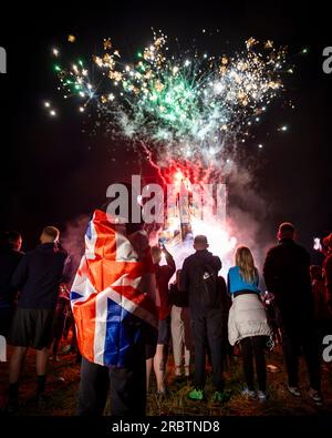 People watch the burning of the loyalist Corcrain bonfire in Portadown ...