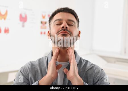 Endocrine system. Man doing thyroid self examination indoors, closeup ...