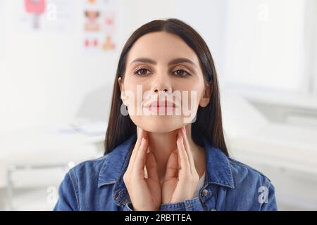 Endocrine system. Young woman doing thyroid self examination on white ...