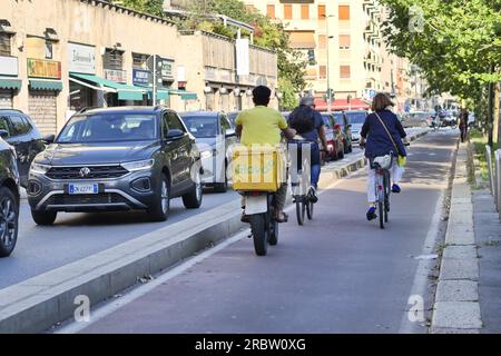 Bicycle food delivery rider working in the street of Milan before ...