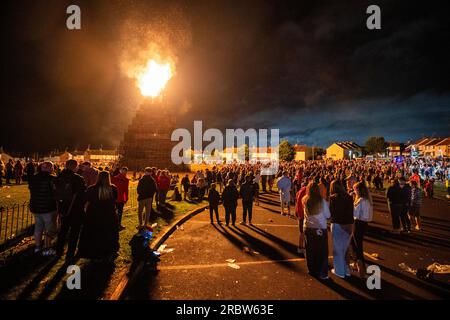 People watch the burning of the loyalist Corcrain bonfire in Portadown ...