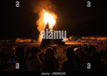 People watch the burning of the loyalist Corcrain bonfire in Portadown ...
