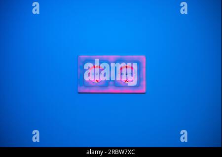 Red illuminated socket to symbolise power consumption and electrical ...