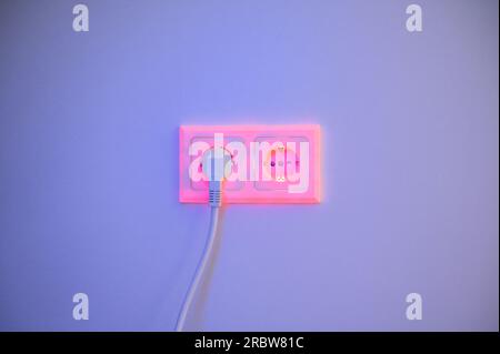 Red and green illuminated socket symbolise power consumption and ...