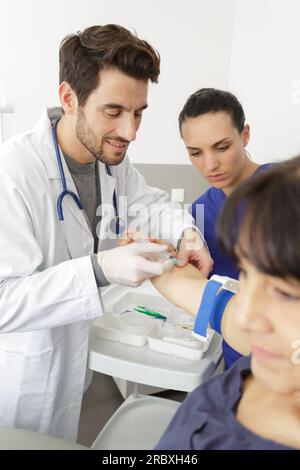 Taking blood sample. Doctor extracting a blood sample from a patient's ...