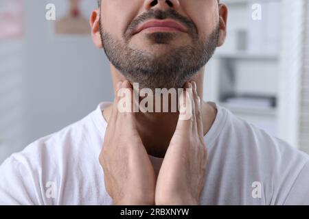 Endocrine system. Man doing thyroid self examination indoors Stock ...