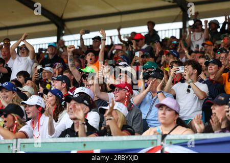 Fans cheer as cars pass by during an SRX Series auto race Saturday ...