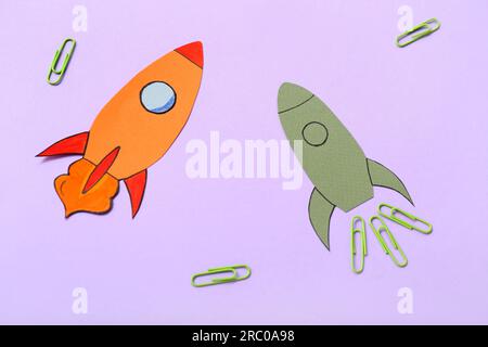 Paper rocket with clips on purple background Stock Photo - Alamy