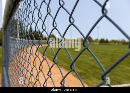 Wire metal fence with baseball field diamond in background. Taken in ...