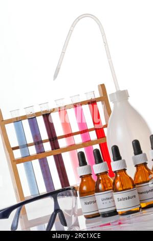Rack with test tubes with coloured substances, glasses, pipette ...