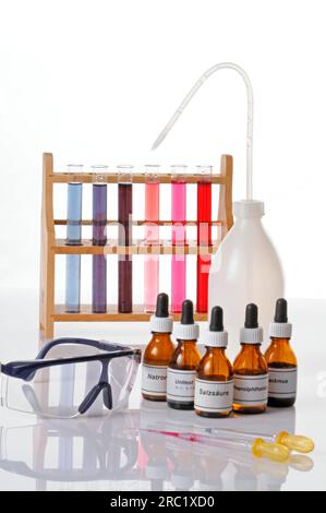 Rack with test tubes with coloured substances, glasses, pipette ...