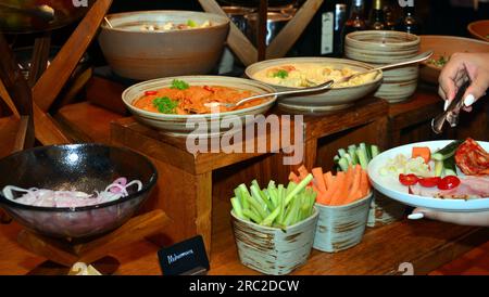 A person chooses food from part of the breakfast buffet at the Grand ...