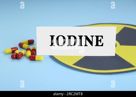 Paper note with word Iodine, radiation signs, cutout of thyroid gland ...