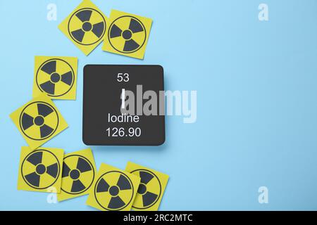 Card with chemical element Iodine and radiation signs on light blue ...