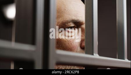 Prisoner standing in prison cell Stock Photo - Alamy