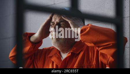 Senior criminal in orange uniform sits on prison bed and dreams about ...