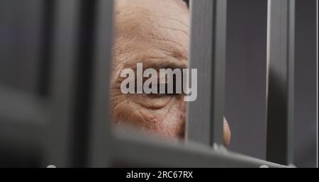 Prisoner standing in prison cell Stock Photo - Alamy