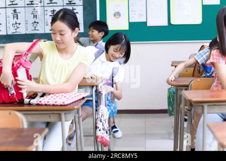 Elementary school students taking their seats after arriving at school ...