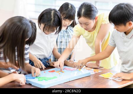 Elementary school students playing in a classroom Stock Photo - Alamy