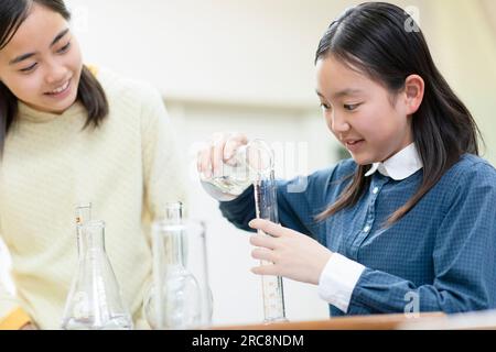 Elementary school students conducting experiments in the classroom ...