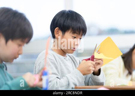 Elementary school students making crafts in the classroom Stock Photo ...