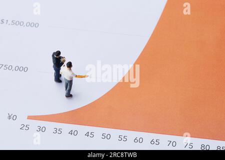People in miniature with graphs Stock Photo - Alamy