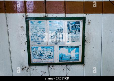 Rail time table and travel posters at the disused Honing railway ...