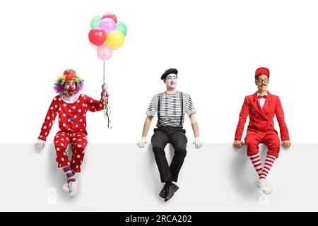 Clown, mime and an entertainer sitting on a blank panel isolated on ...