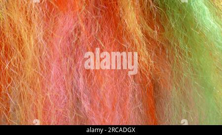 Horizontal picture of fluffy wool-like threads in the colours orange ...