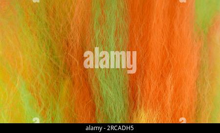 Horizontal picture of fluffy wool-like threads in the colours orange ...