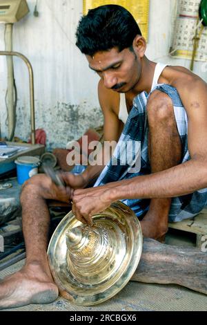 An artisan working carving on brass lamp at NachiyarKoil Nachiyar Koil ...
