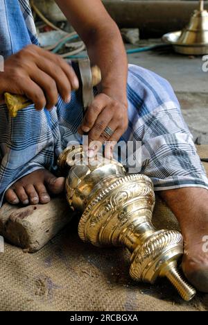 An artisan working carving on brass lamp at NachiyarKoil Nachiyar Koil ...