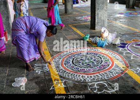 Drawing kolam, rangoli inside the temple floor, Sri Neelayadhakshi ...