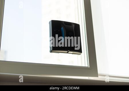 The white robotic window cleaner uses a brush and vacuum for a thorough ...