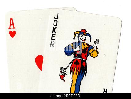 Vintage playing cards showing a joker and an ace of spades on a white ...