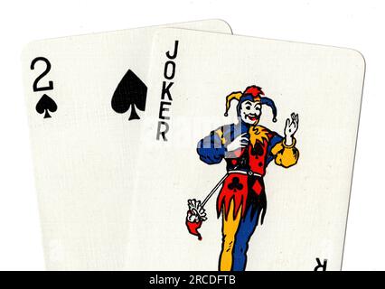 Vintage playing cards showing a joker and an ace of spades on a white ...