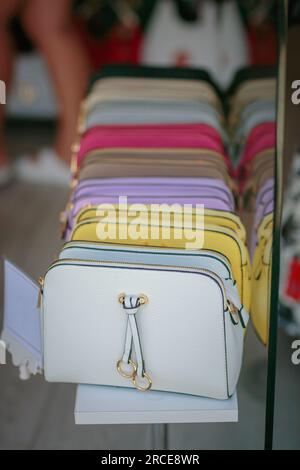 Adult female shopper choosing handbag in clothing store Stock Photo - Alamy