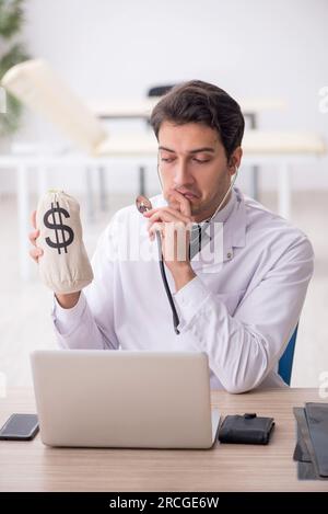 Young doctor in remuneration concept Stock Photo - Alamy