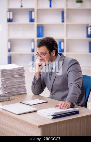 Young businessman employee unhappy with excessive work at workplace ...
