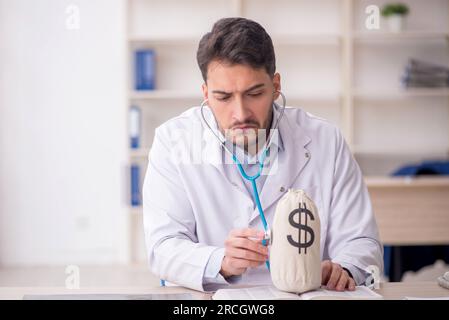 Young doctor in remuneration concept Stock Photo - Alamy