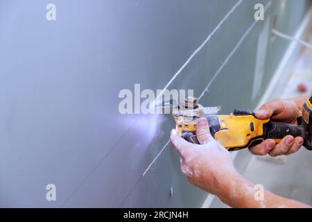 Multitool was used to cut plasterboard with single blade saw to lay an ...