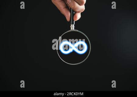 Magnifying glass highlights infinity symbol icons Stock Photo - Alamy